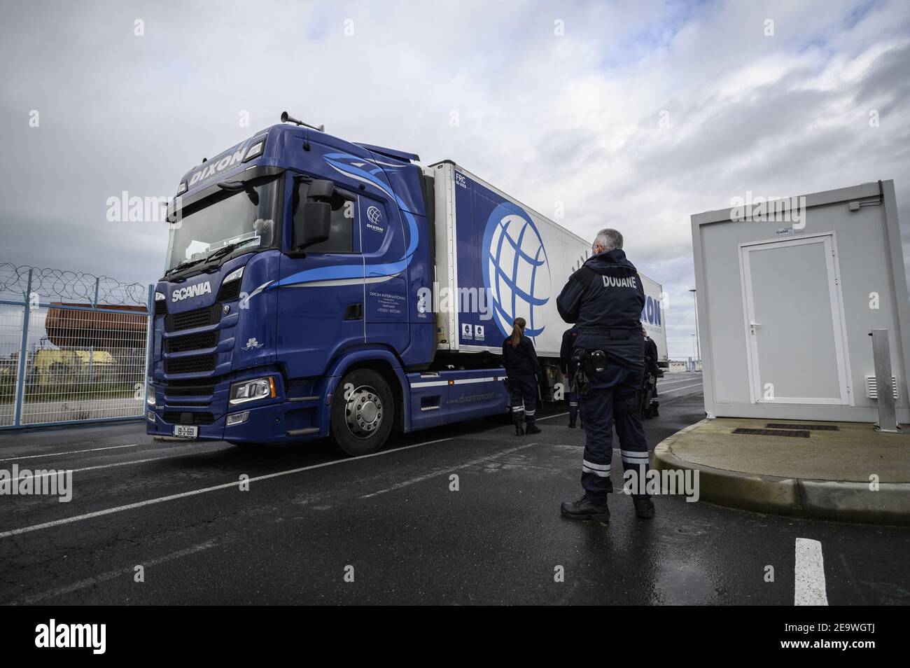 French Customs officers look on trucks arriving for embarkation at the ...