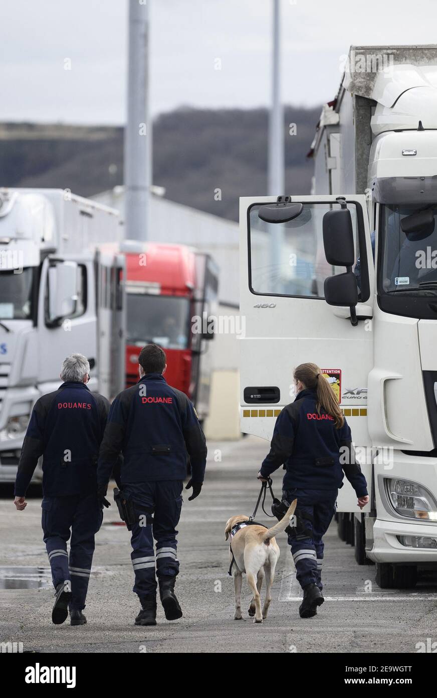 French Customs officers look on trucks arriving for embarkation at the ...