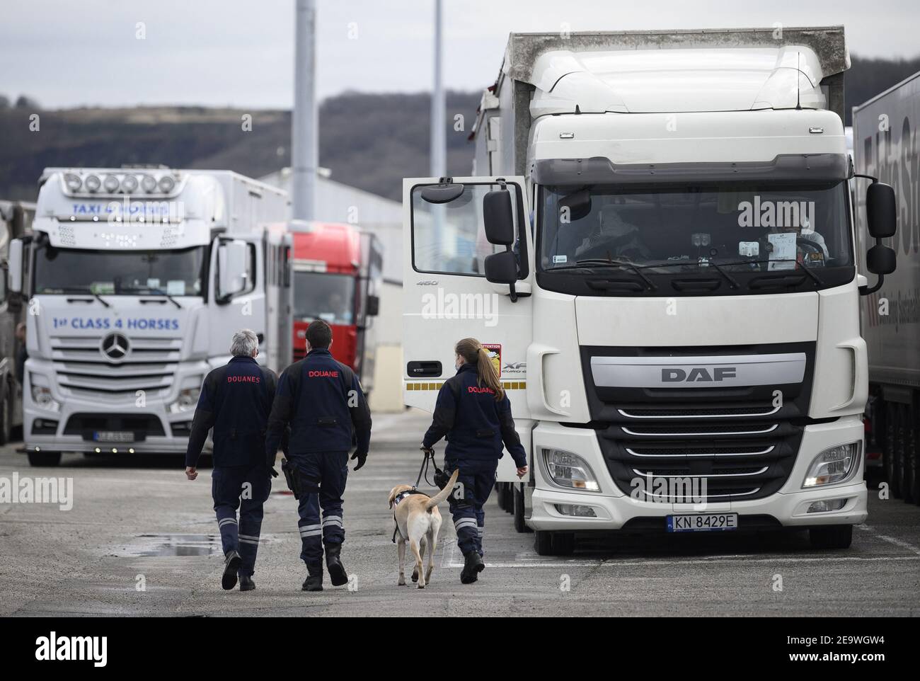 French Customs officers look on trucks arriving for embarkation at the ...