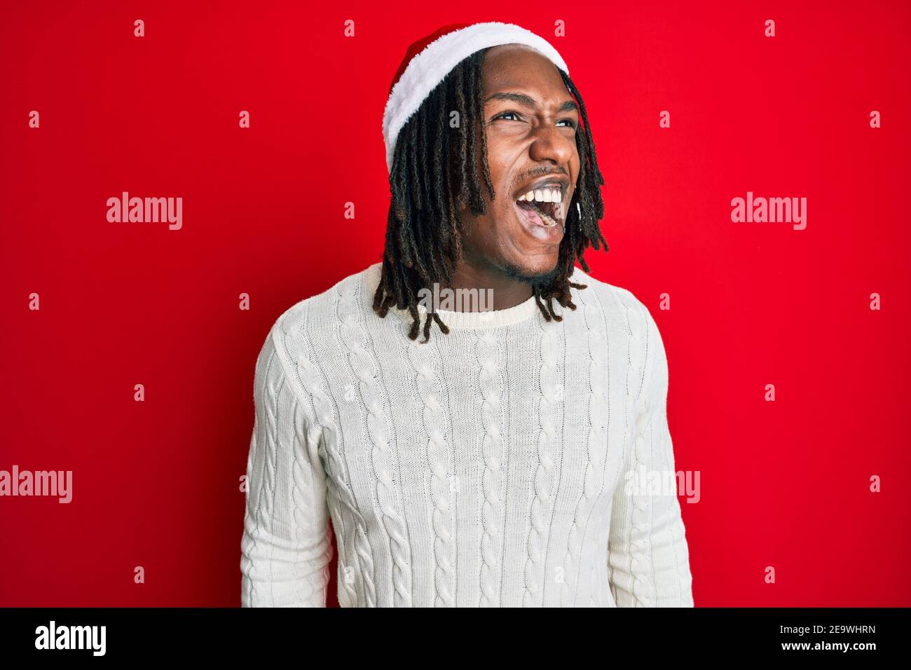 African american man with braids wearing christmas hat angry and mad ...