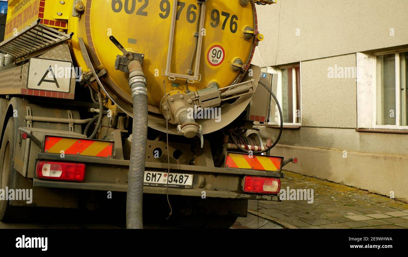 Septic cesspool pumping into tank truck by suction hose under high ...