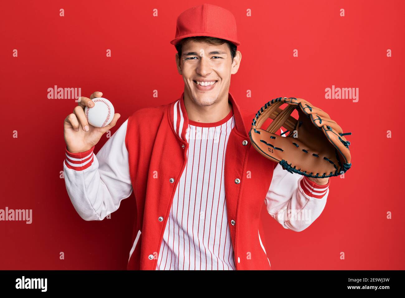 Handsome caucasian man wearing baseball uniform holding golve and ball ...
