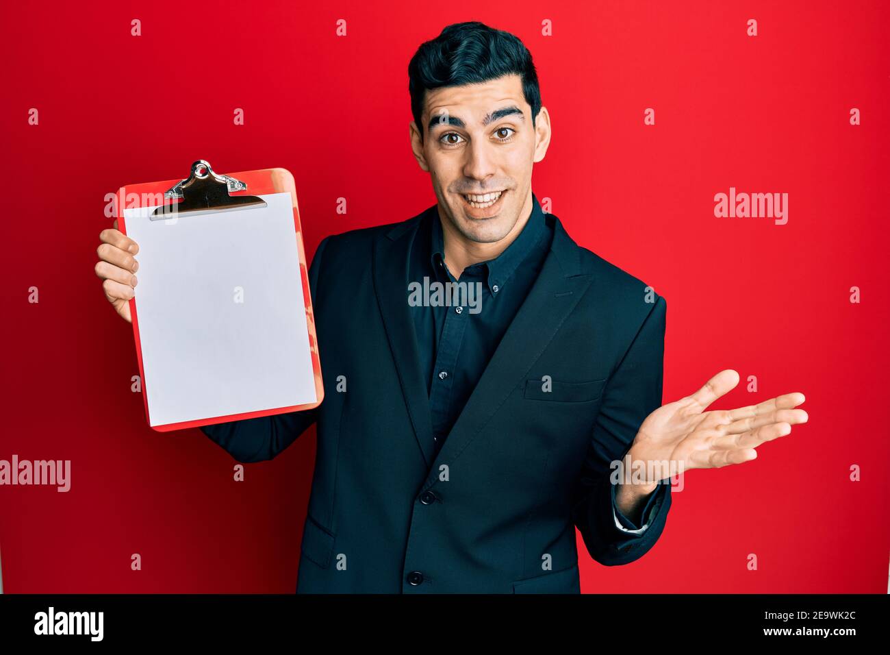 Handsome hispanic business man holding clipboard with blank space ... Handsome hispanic business man holding clipboard with blank space ...