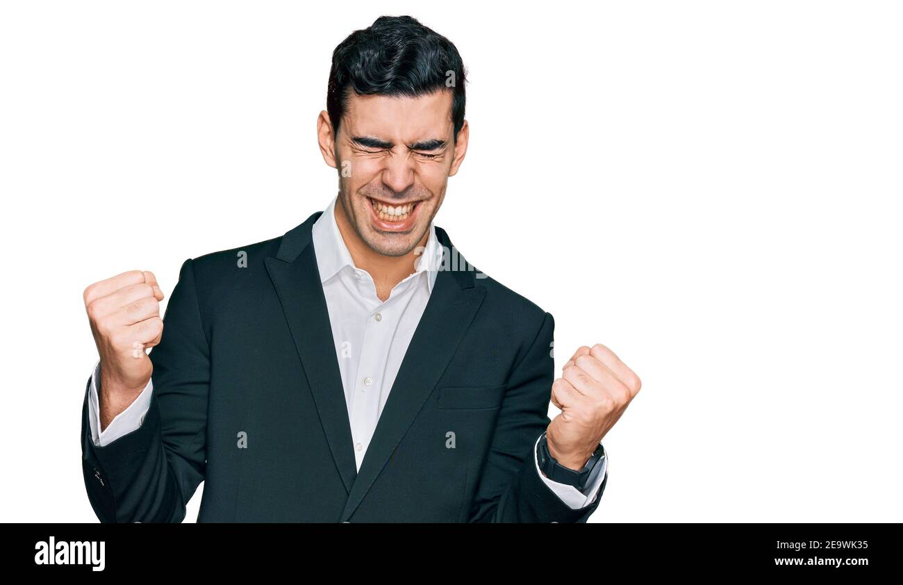 Handsome hispanic man wearing business clothes very happy and excited ...