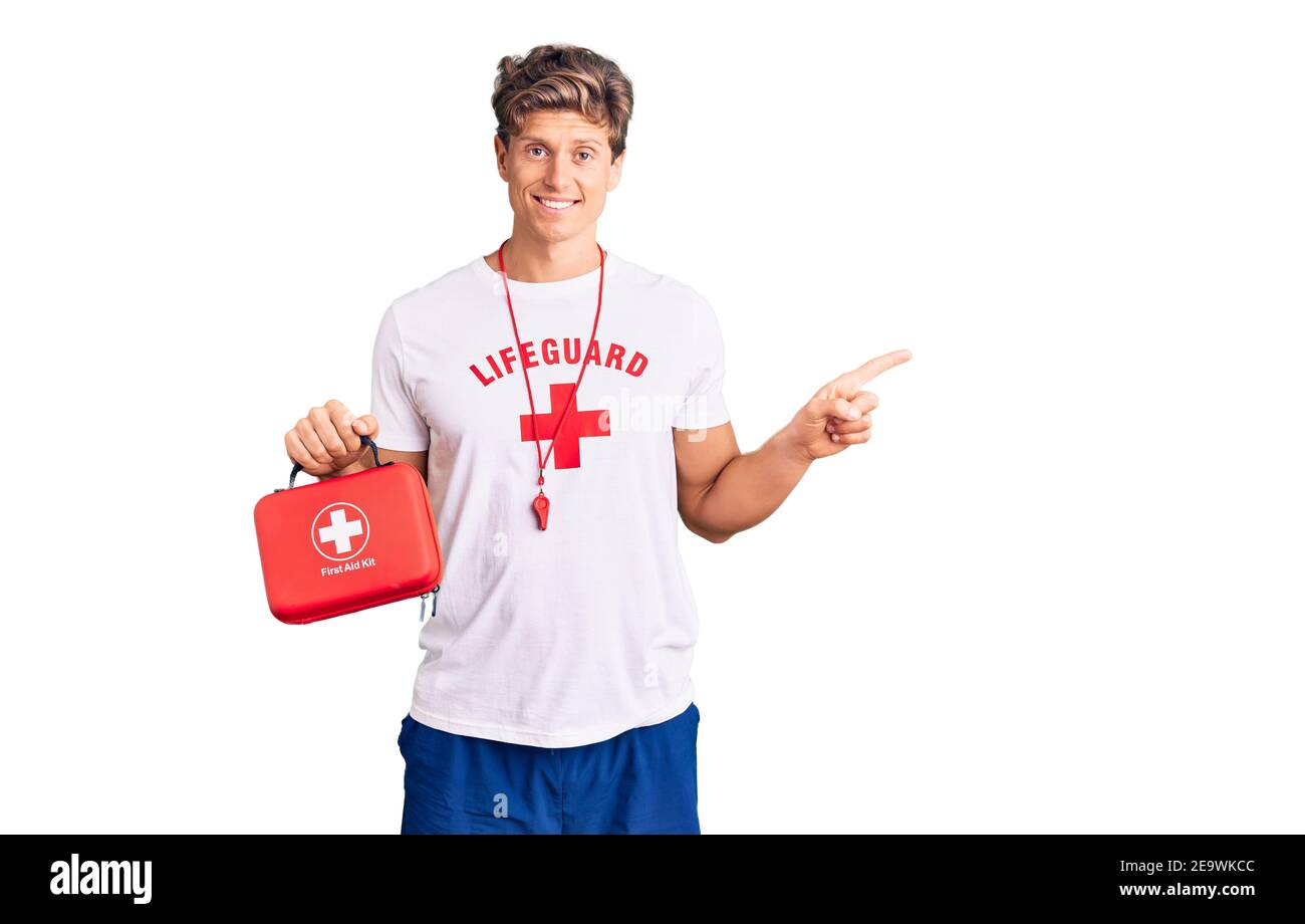 Young handsome man wearing lifeguard t shirt holding first aid kit ...