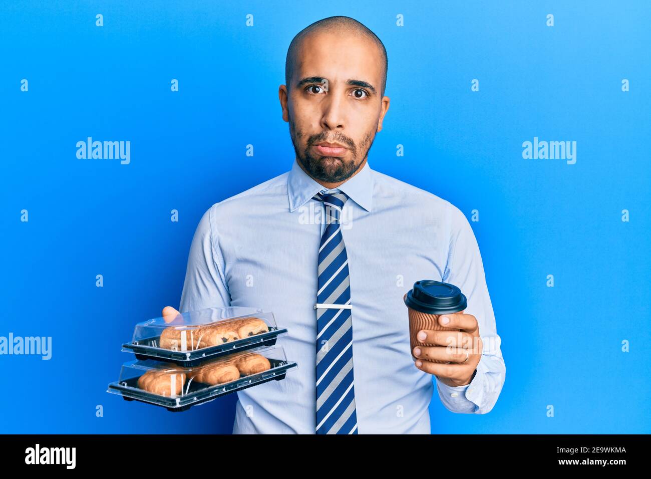 Hispanic adult business man holding take away coffee and sweets ...