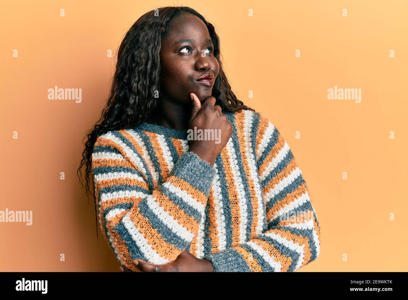 African young woman wearing wool winter sweater serious face thinking ...