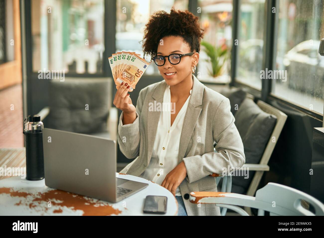 Young african american businesswoman holding 50 euro banknotes sitting ...