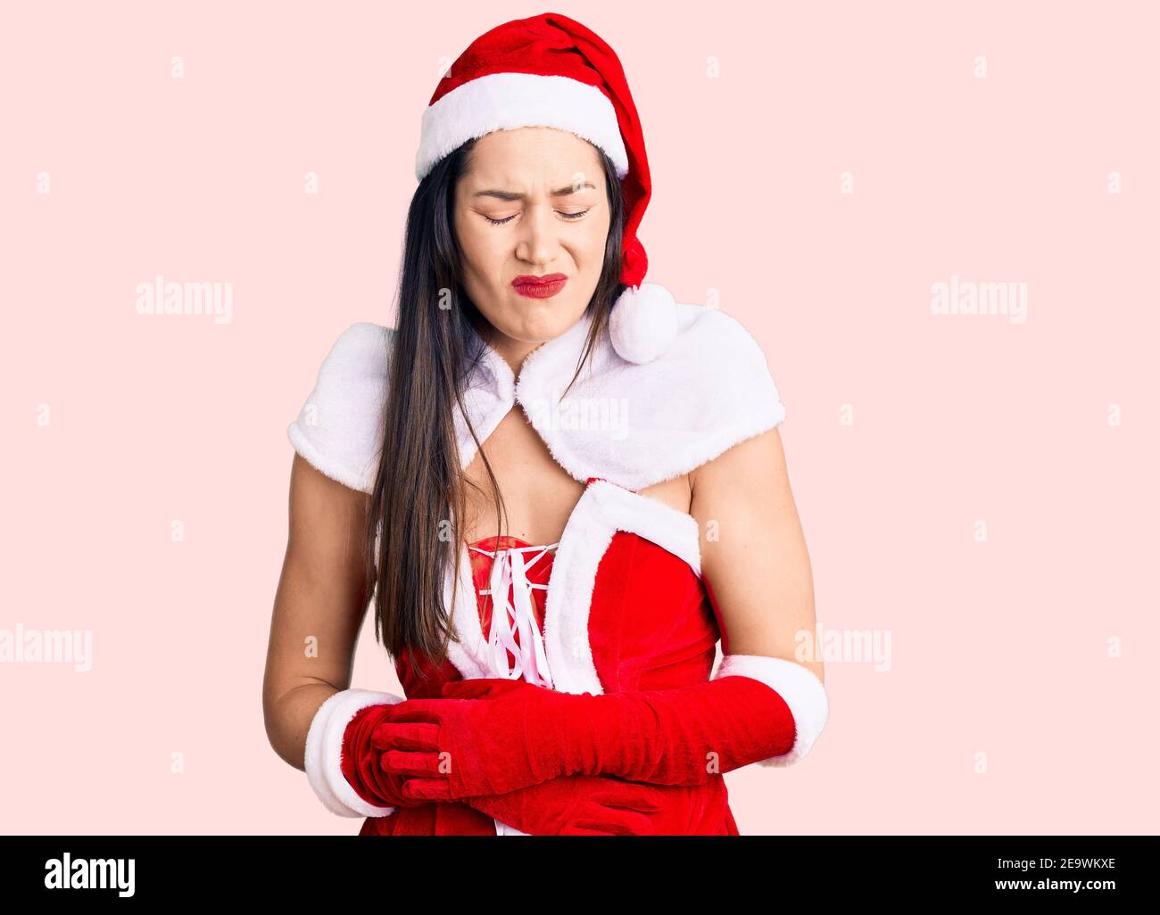Young beautiful caucasian woman wearing santa claus costume with hand ...