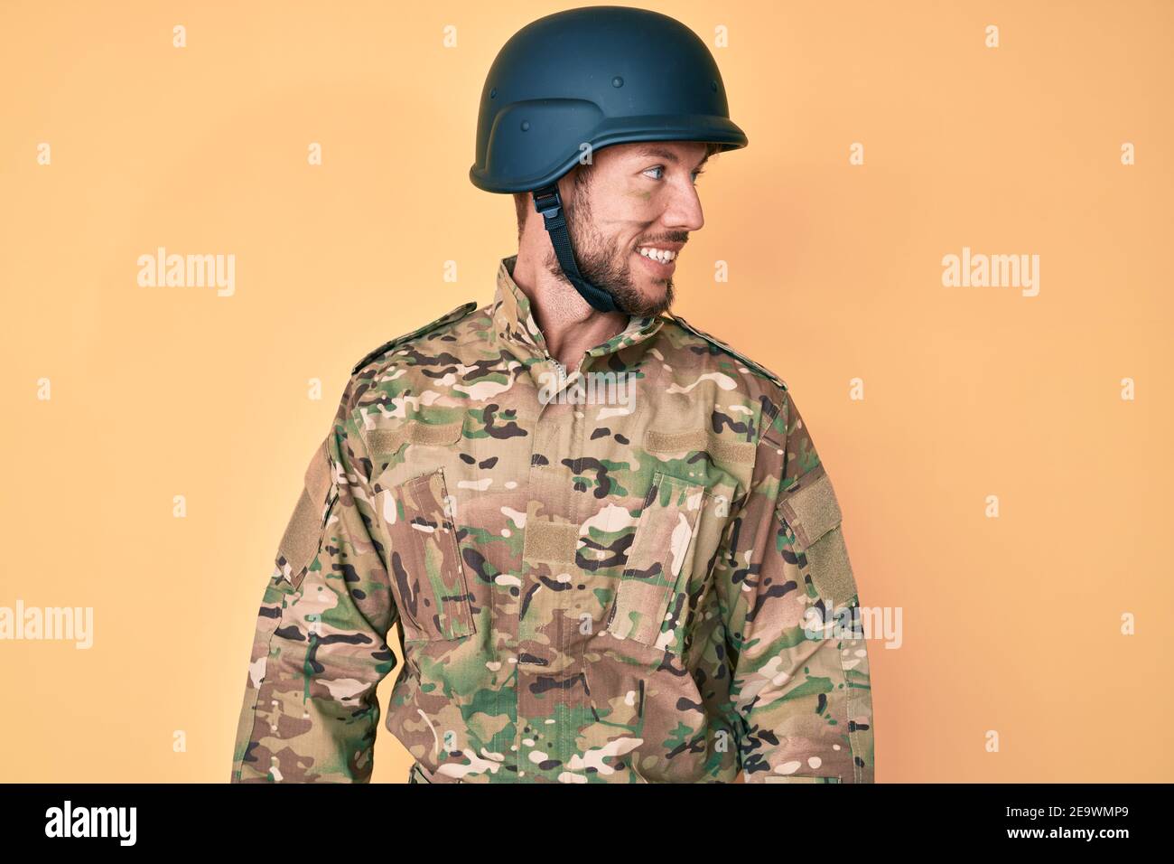 Young caucasian man wearing camouflage army uniform looking to side ...