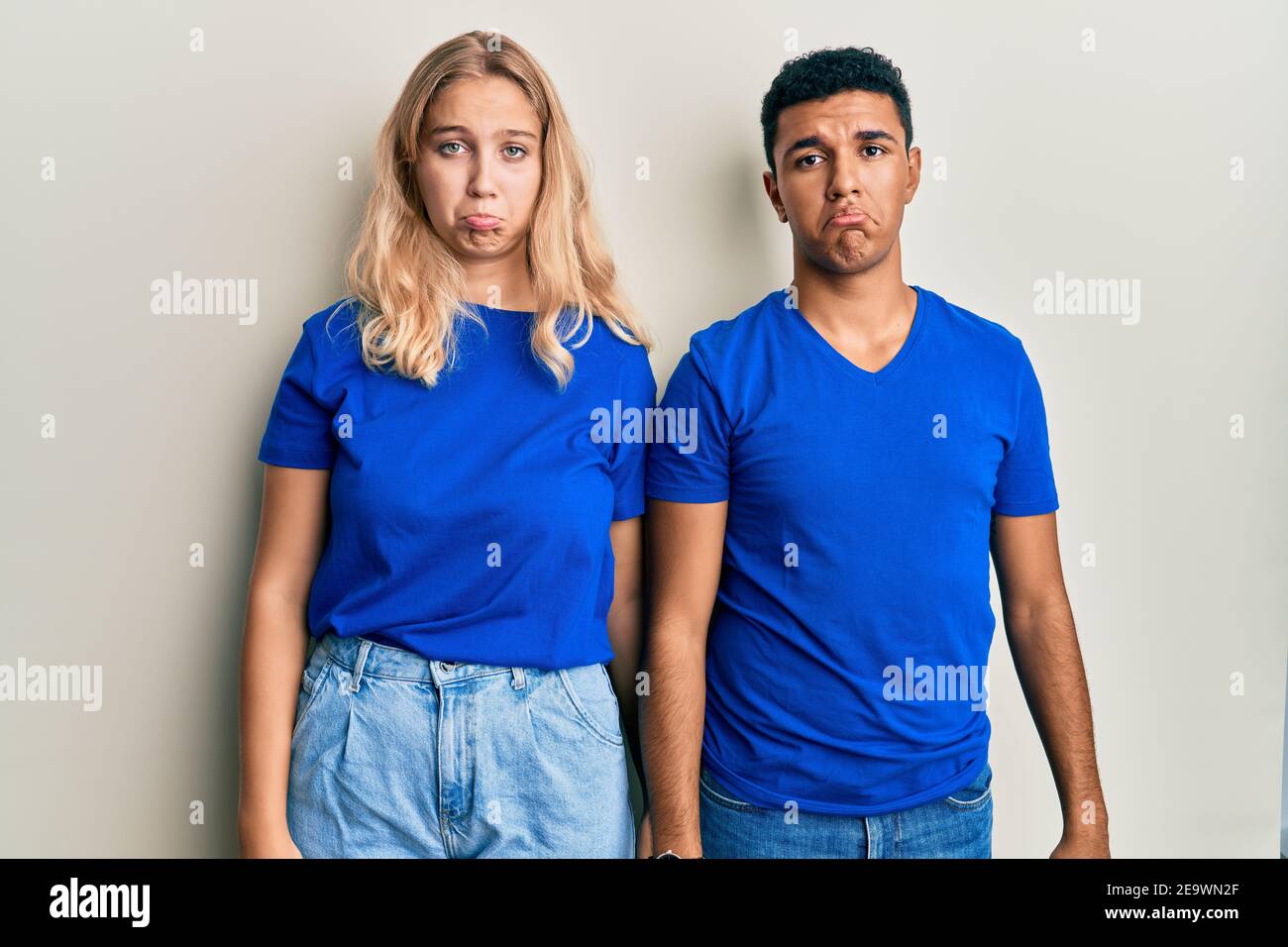 Young interracial couple wearing casual clothes depressed and worry for ...