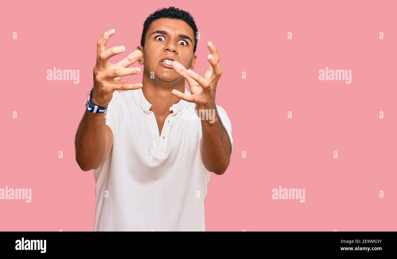 Young arab man wearing casual clothes shouting frustrated with rage ...