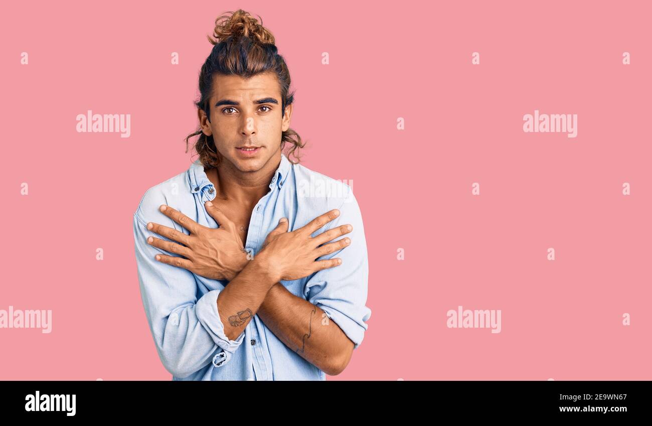 Young hispanic man wearing summer style shaking and freezing for winter ...