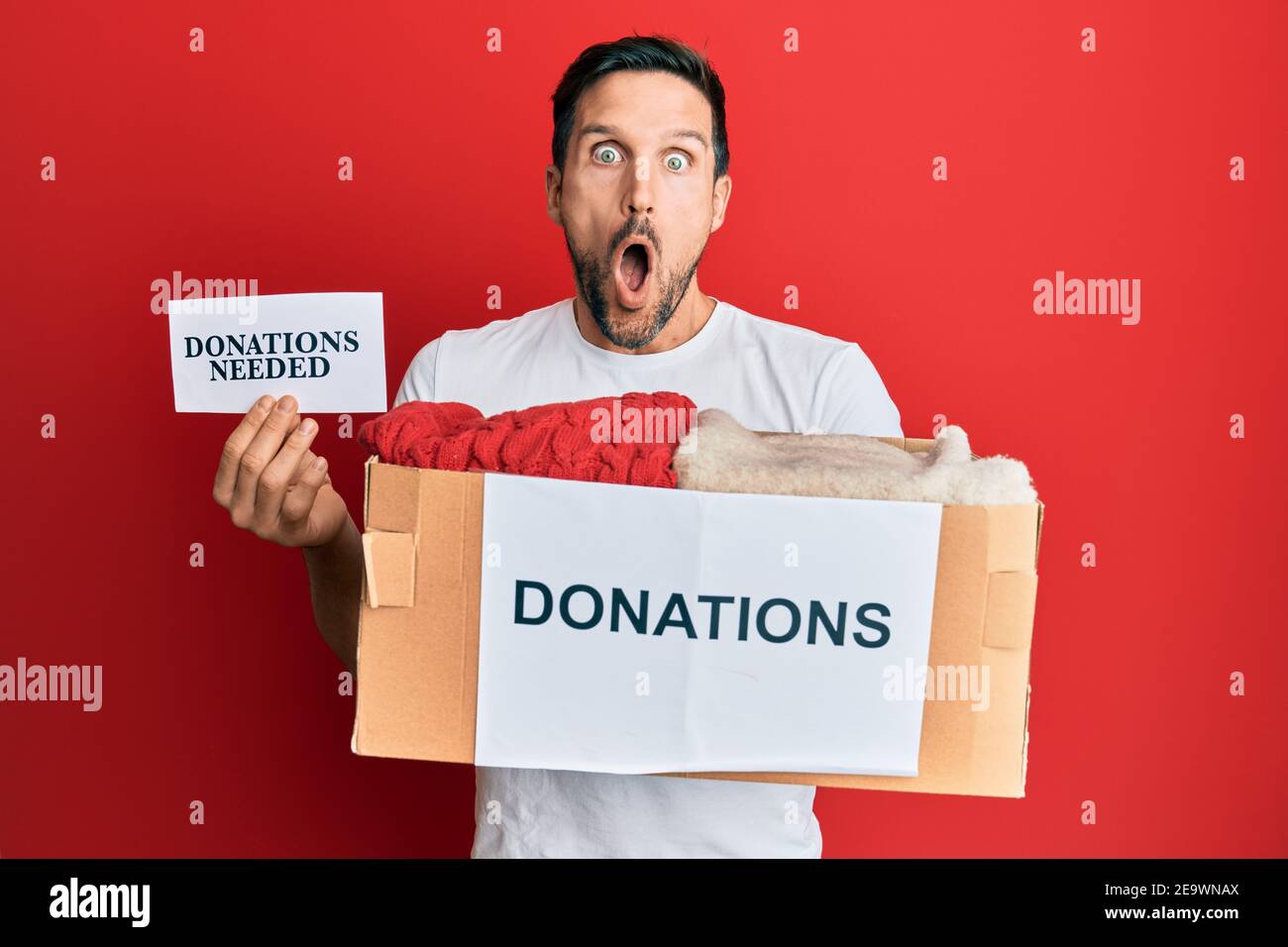 Young handsome man volunteer holding box and donations needed paper ...