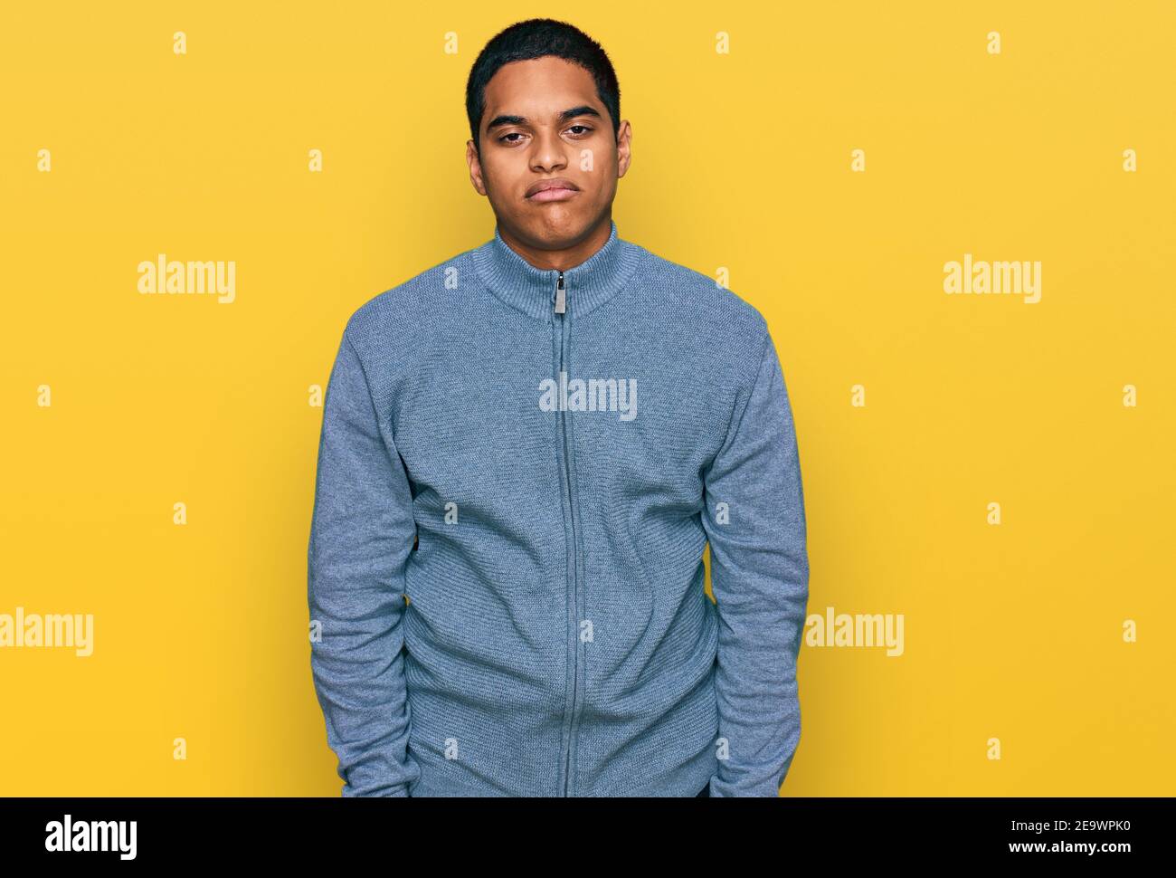 Young handsome hispanic man wearing casual sweatshirt looking sleepy ...