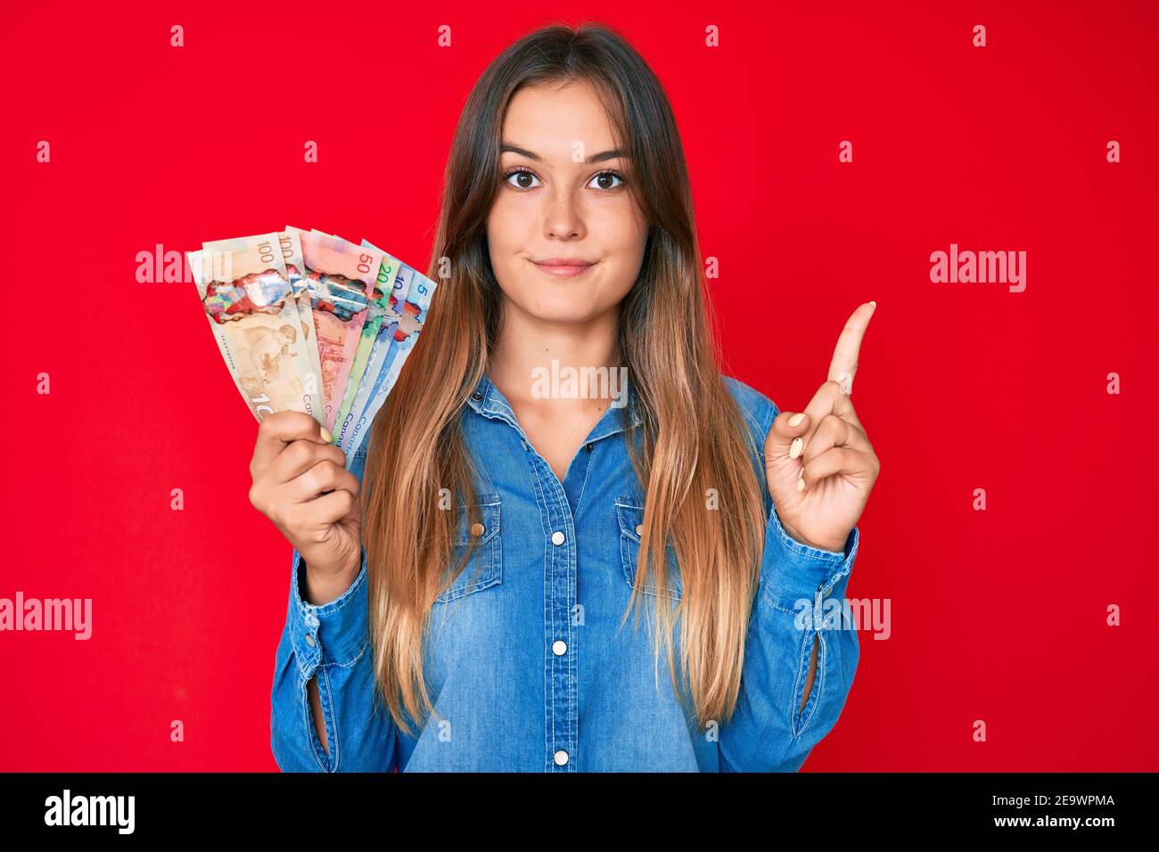 Beautiful caucasian woman holding canadian dollars smiling happy ...