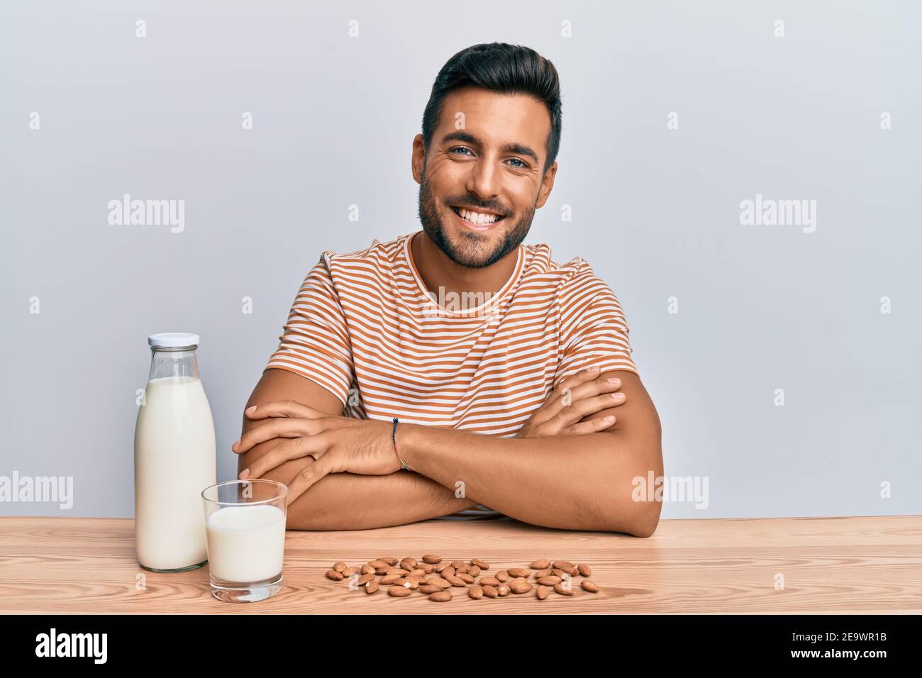 Handsome hispanic man drinking healthy almond milk happy face smiling ...