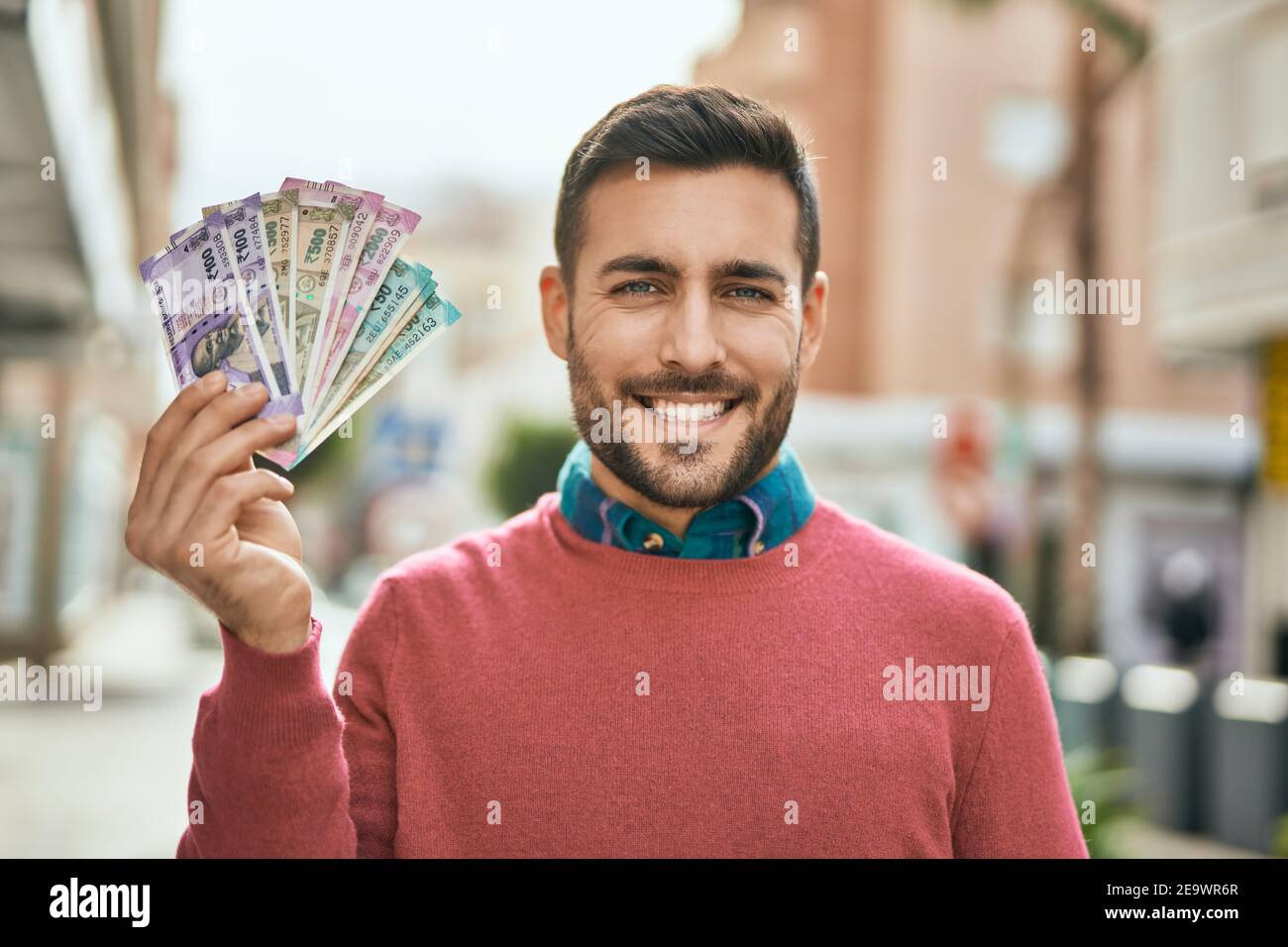 Young hispanic man smiling happy standing at the city Stock Photo - Alamy