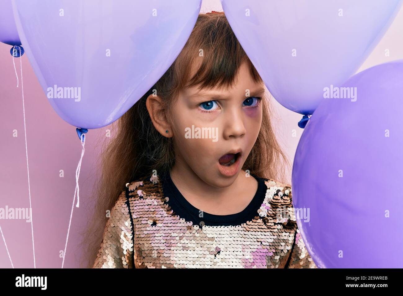 Little caucasian girl kid holding balloons in shock face, looking ...