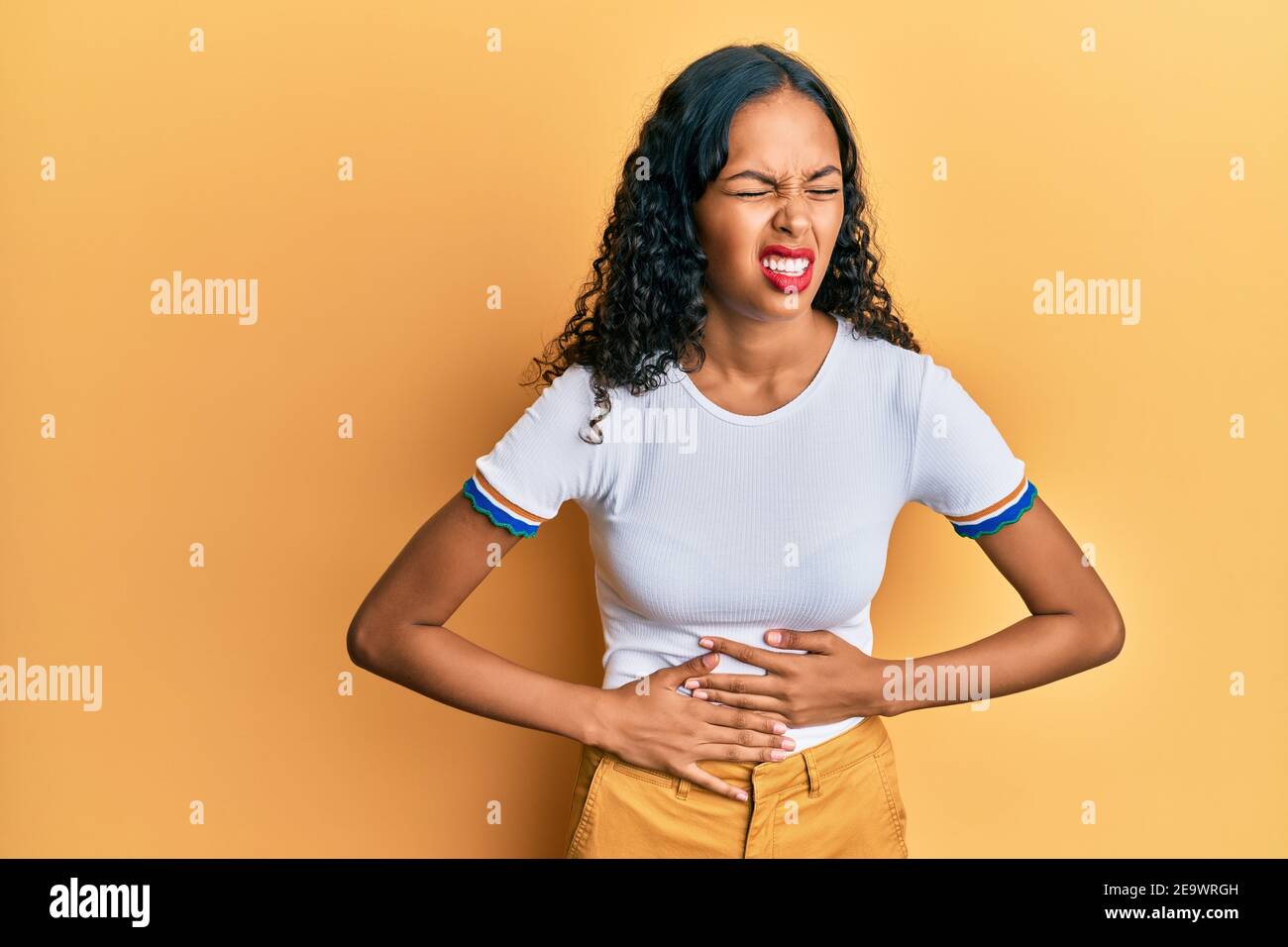 Young african american girl wearing casual clothes with hand on stomach ...