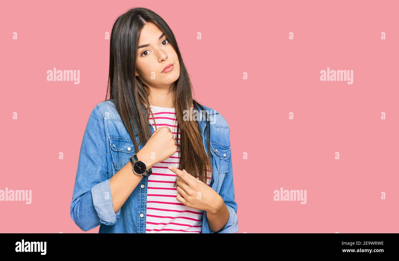 Young Brunette Woman Wearing Casual Clothes In Hurry Pointing To Watch