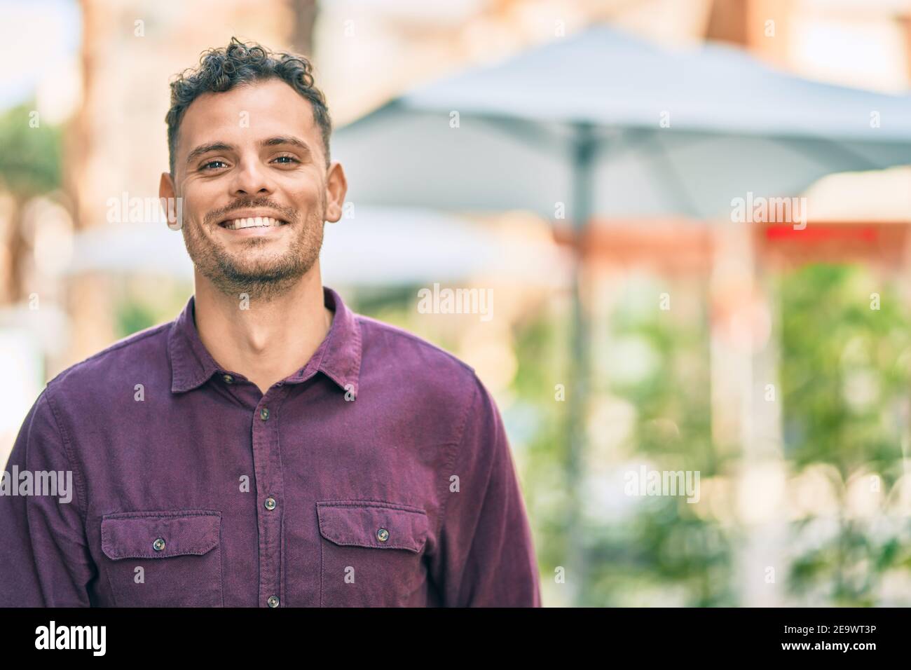 Young hispanic man smiling happy standing at the city Stock Photo - Alamy
