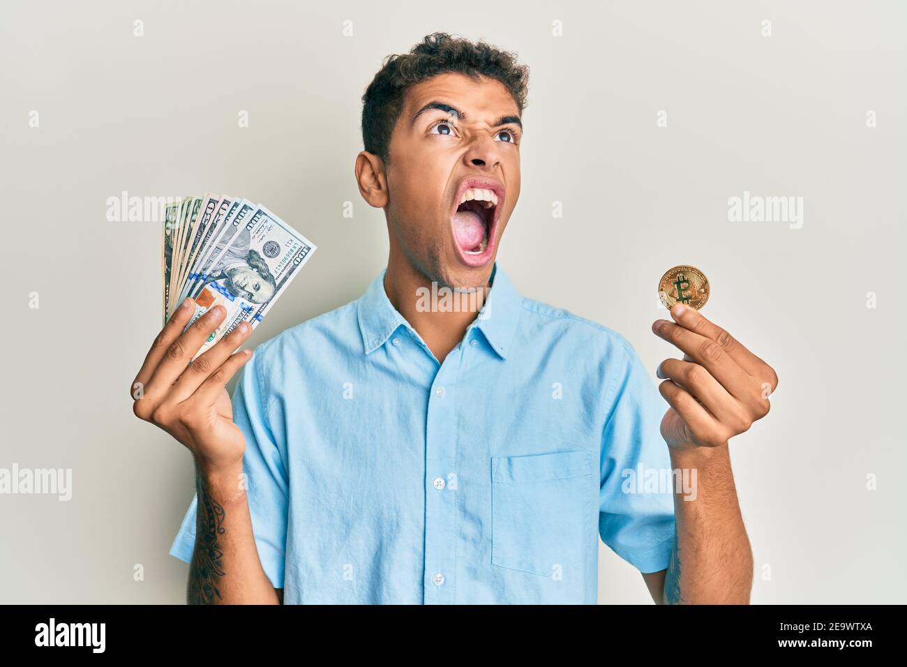 Young handsome african american man holding virtual currency bitcoin ...