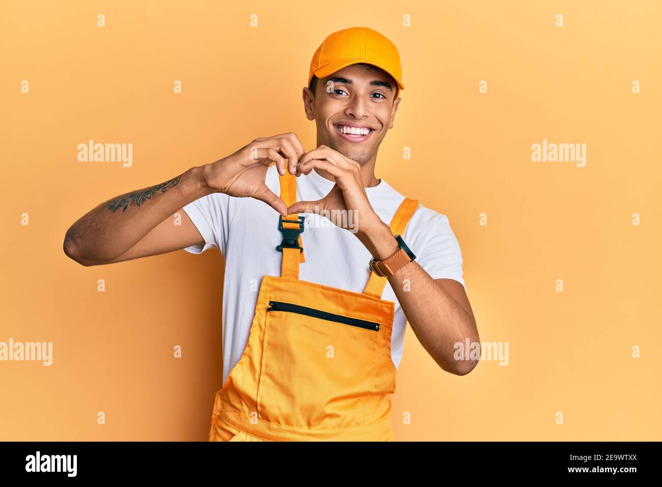 Young handsome african american man wearing handyman uniform over ...