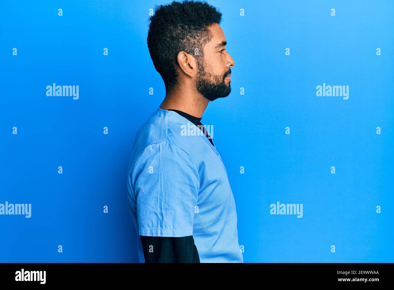 Handsome hispanic man with beard wearing blue male nurse uniform ...