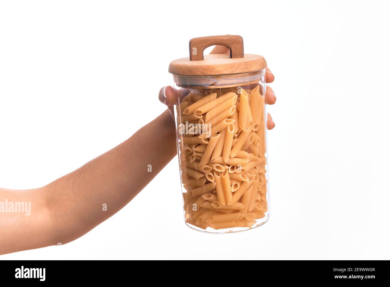 Glass jar full of dry italian penne pasta over isolated background ...