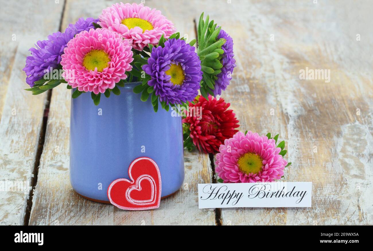 Happy birthday card with colorful pink daisies in blue vase on rustic ...