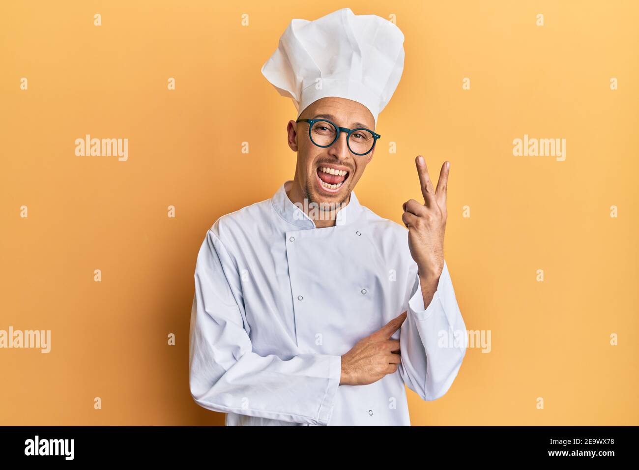 Bald man with beard wearing professional cook uniform smiling with ...