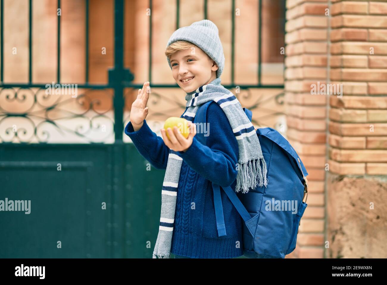 Adorable blond student kid saying goodbye with hand getting in the ...