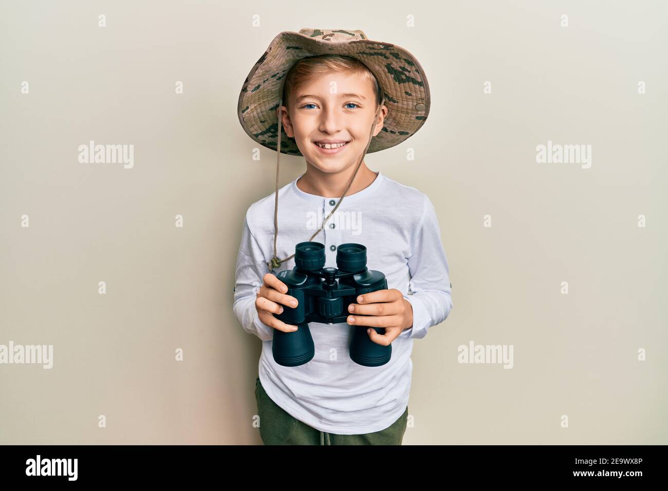 Little caucasian boy kid wearing explorer hat holding binoculars ...