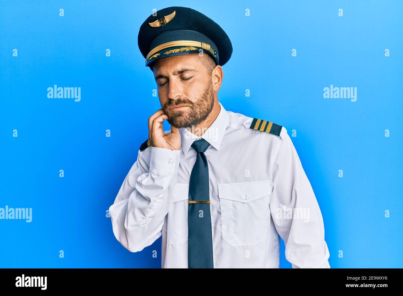 Handsome Man With Beard Wearing Airplane Pilot Uniform Touching Mouth