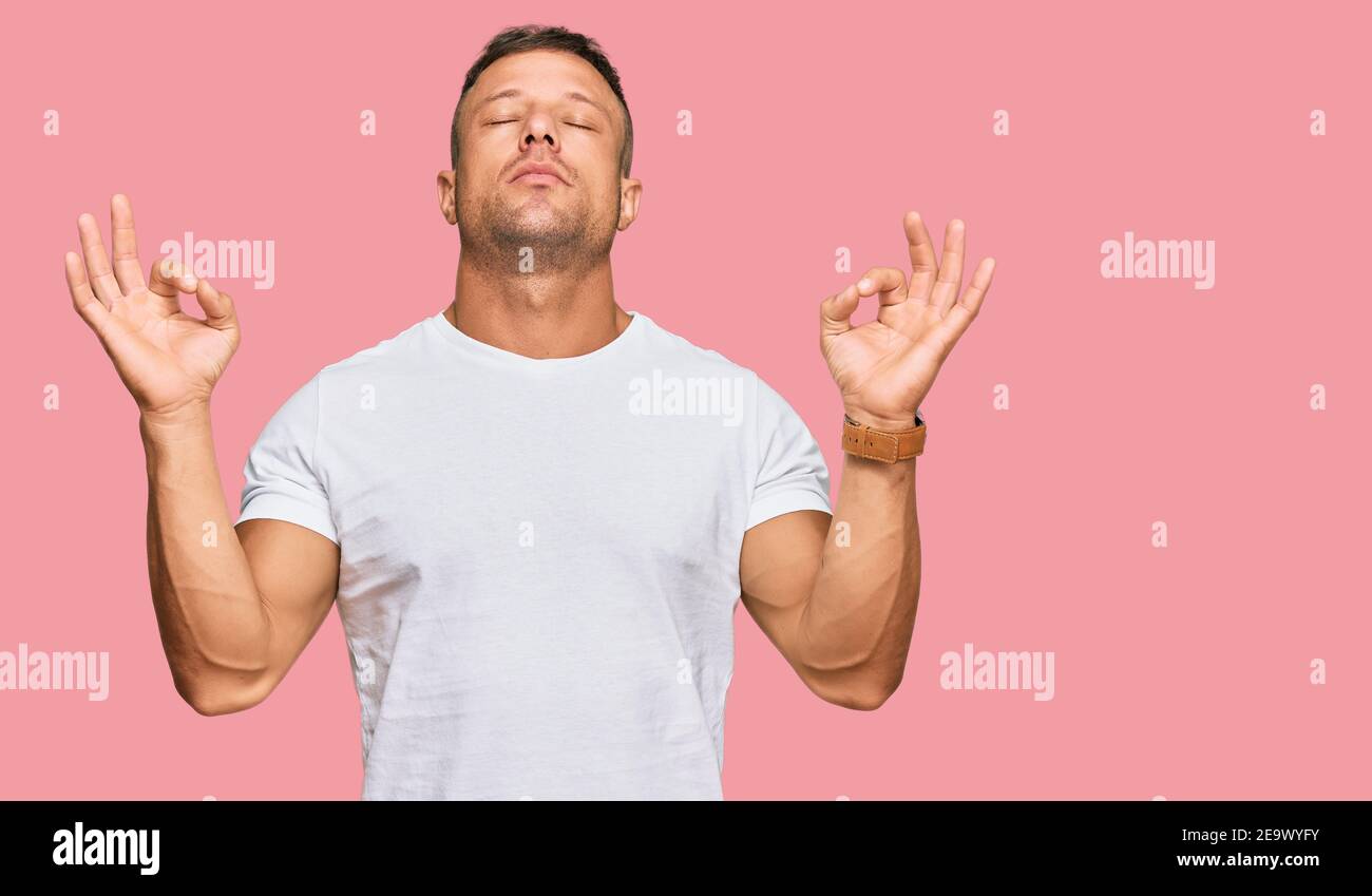 Handsome muscle man wearing casual white tshirt relaxed and smiling ...