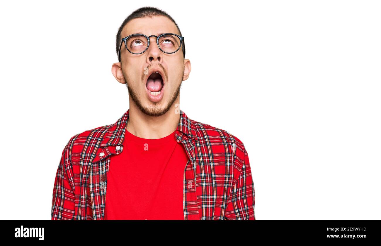 Hispanic young man wearing casual clothes angry and mad screaming ...