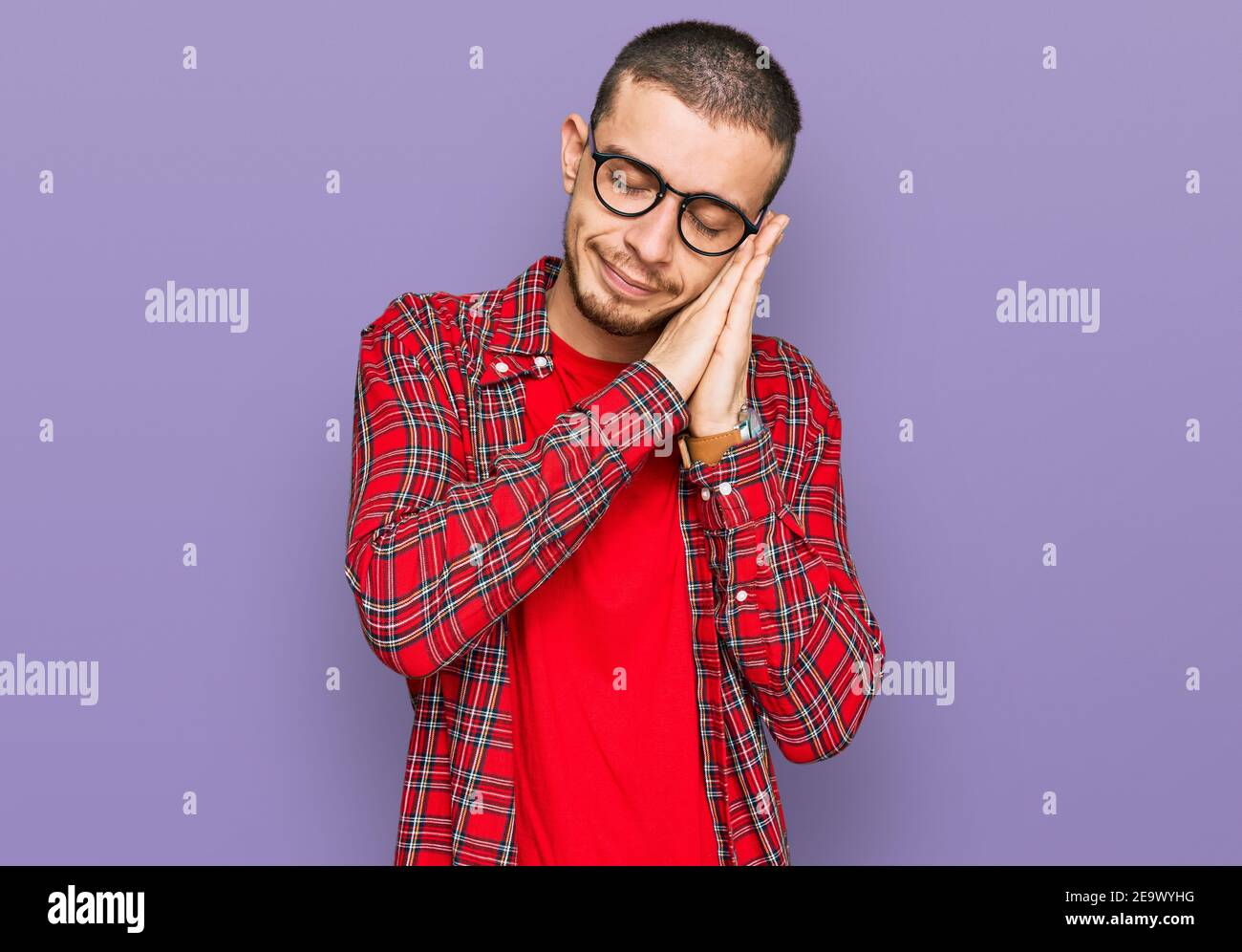 Hispanic young man wearing casual clothes sleeping tired dreaming and ...