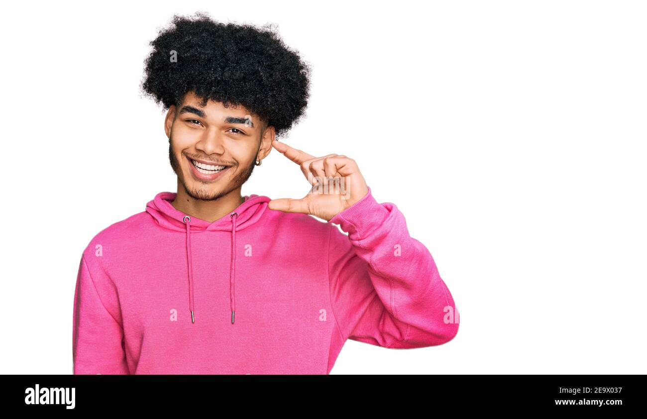 Young african american man with afro hair wearing casual pink ...