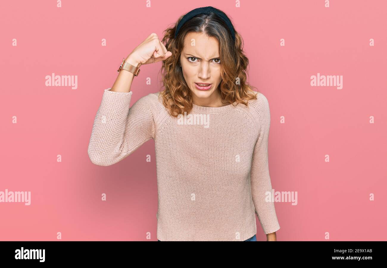 Beautiful young caucasian woman wearing casual sweater angry and mad ...