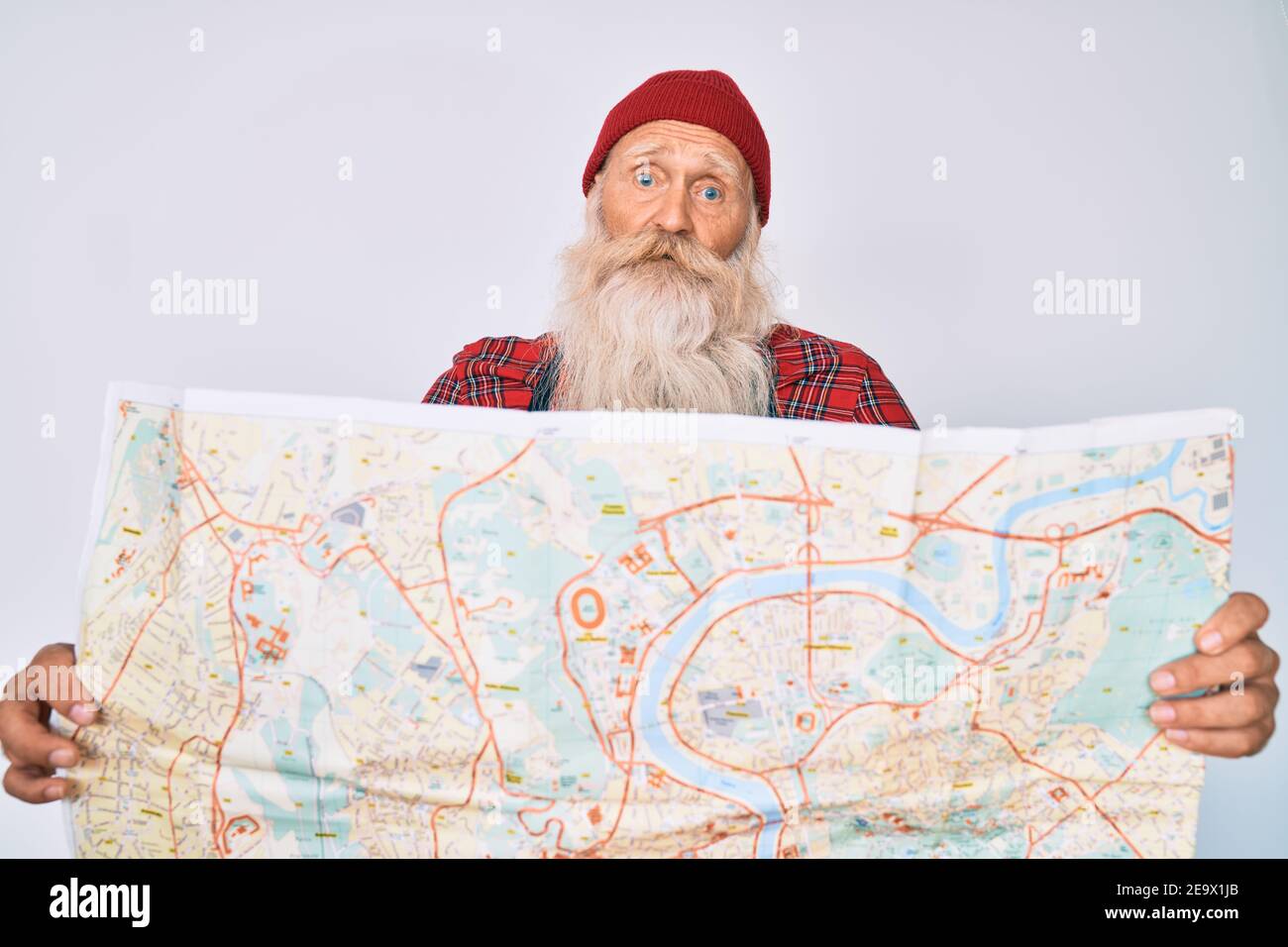 Old senior man with grey hair and long beard holding city map clueless ...