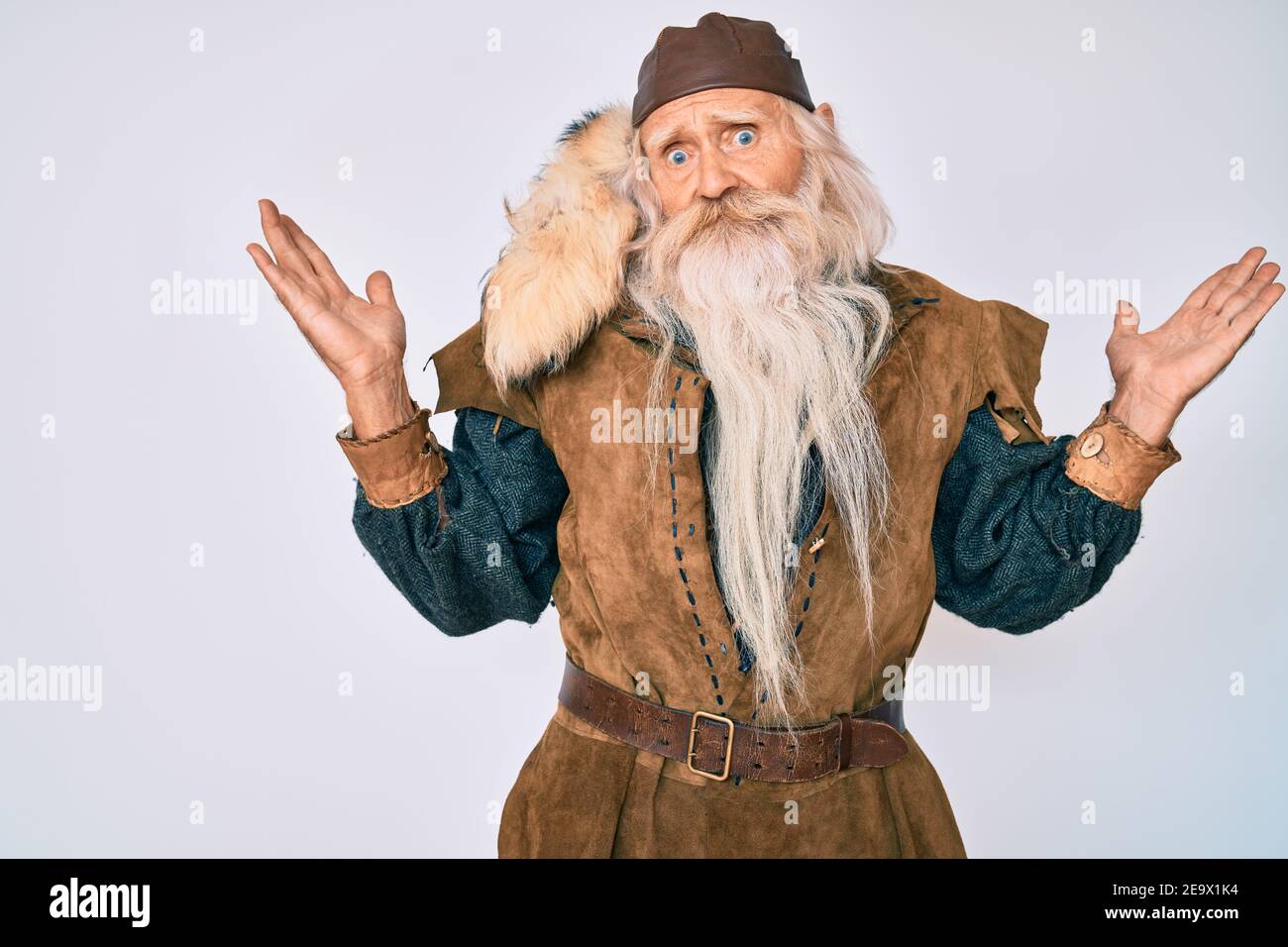 Old senior man with grey hair and long beard wearing viking traditional ...