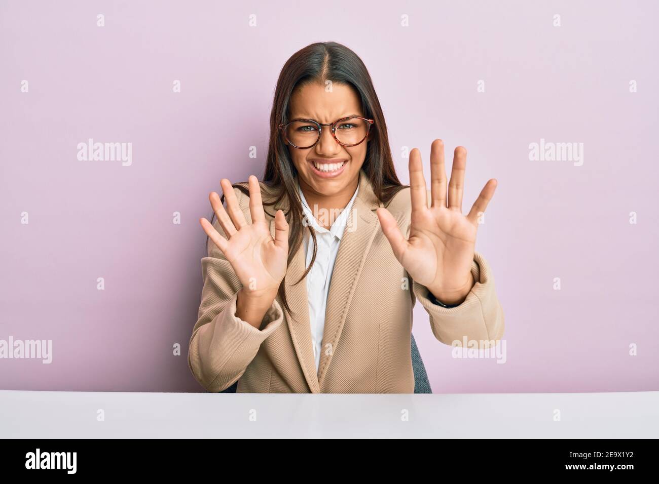 Beautiful hispanic woman working at the office afraid and terrified ...