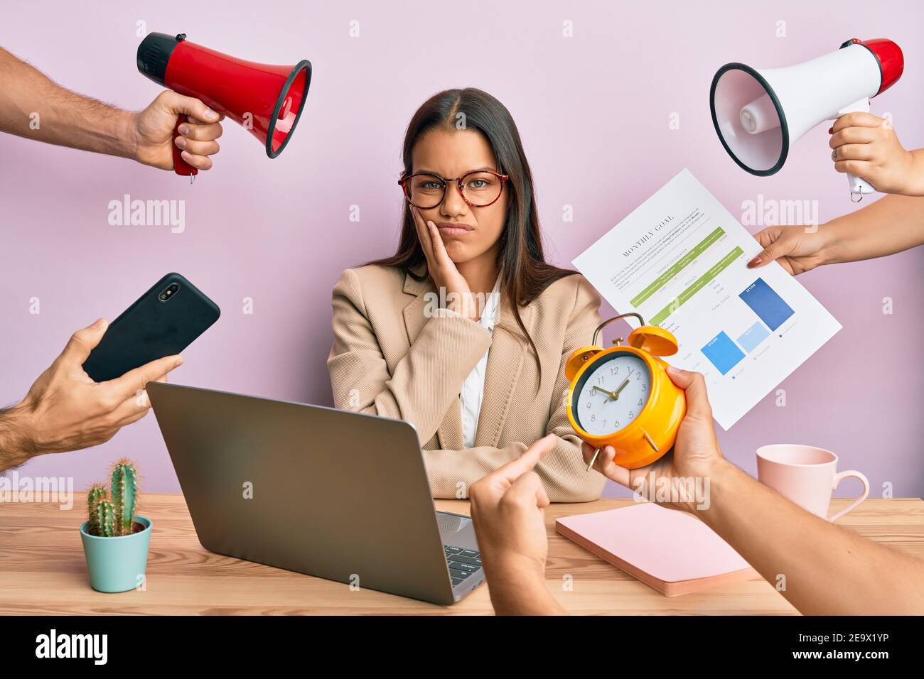Beautiful hispanic woman working at the office under stress thinking ...