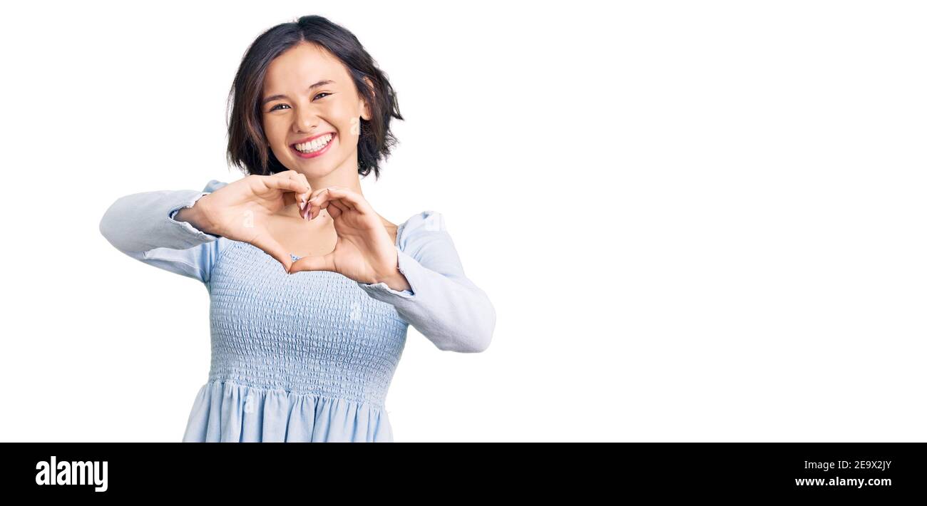 Young beautiful girl wearing casual clothes smiling in love doing heart ...