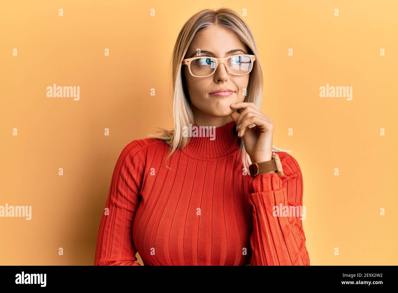 Beautiful blonde woman wearing casual clothes and glasses thinking ...