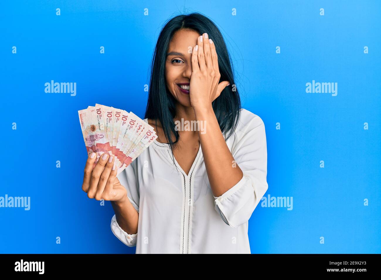 Young african american woman holding 10 colombian pesos banknotes ...