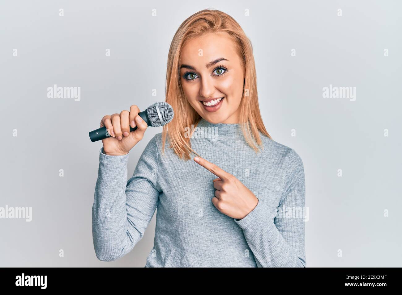 Beautiful caucasian woman singing song using microphone smiling happy ...