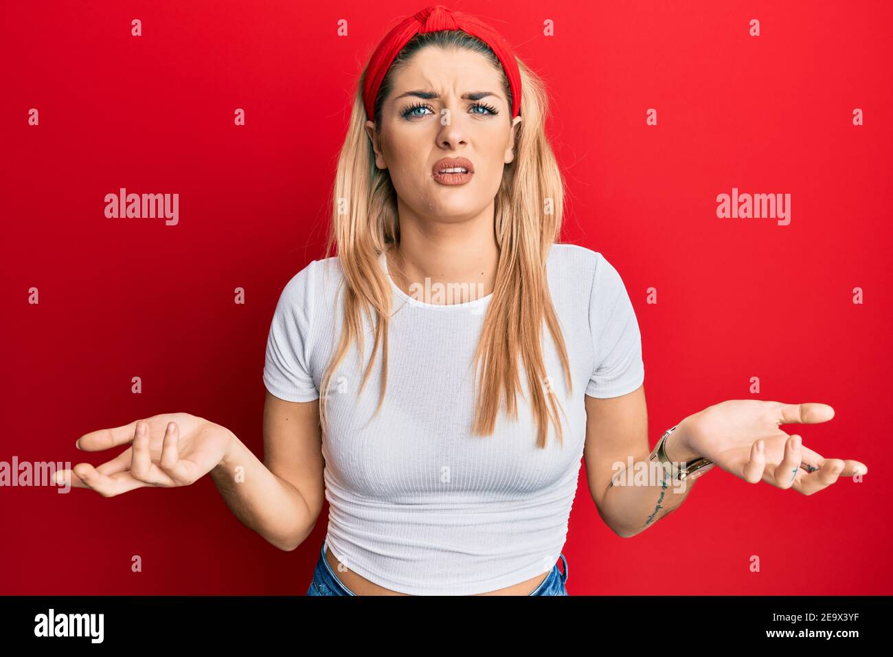 Young caucasian woman wearing casual white t shirt clueless and ...