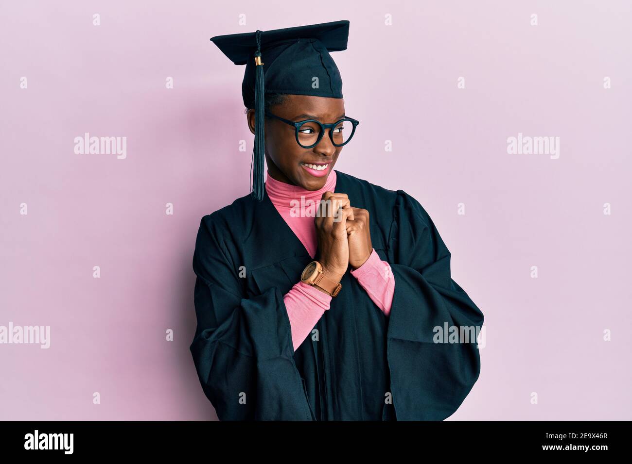 Young african american girl wearing graduation cap and ceremony robe ...